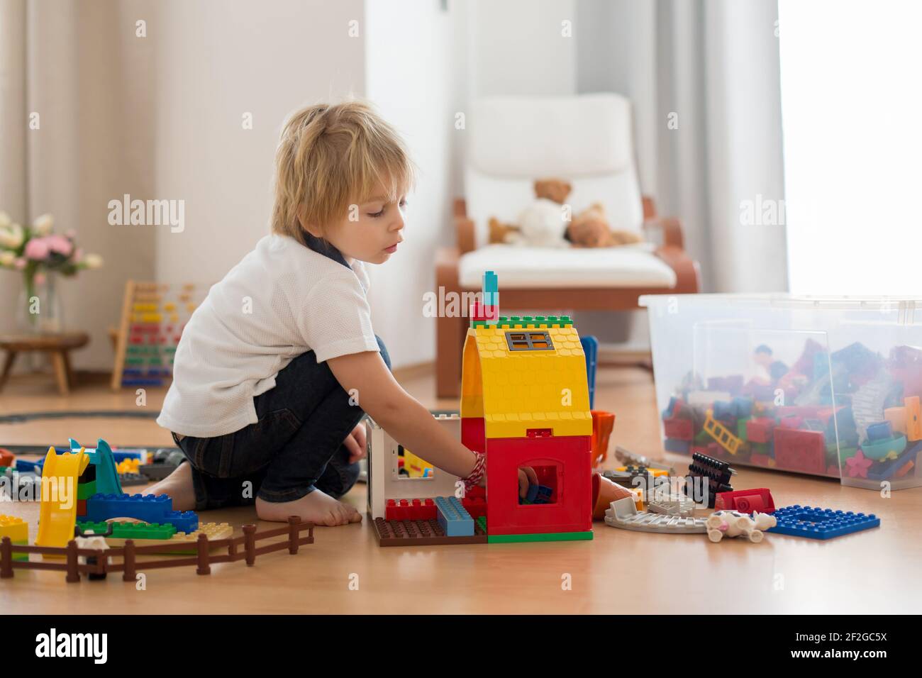 Cute child, playing with colorful toy blocks. Little boy building house ...