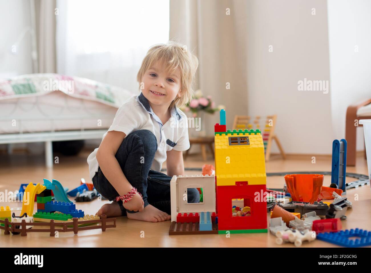 Cute child, playing with colorful toy blocks. Little boy building house ...