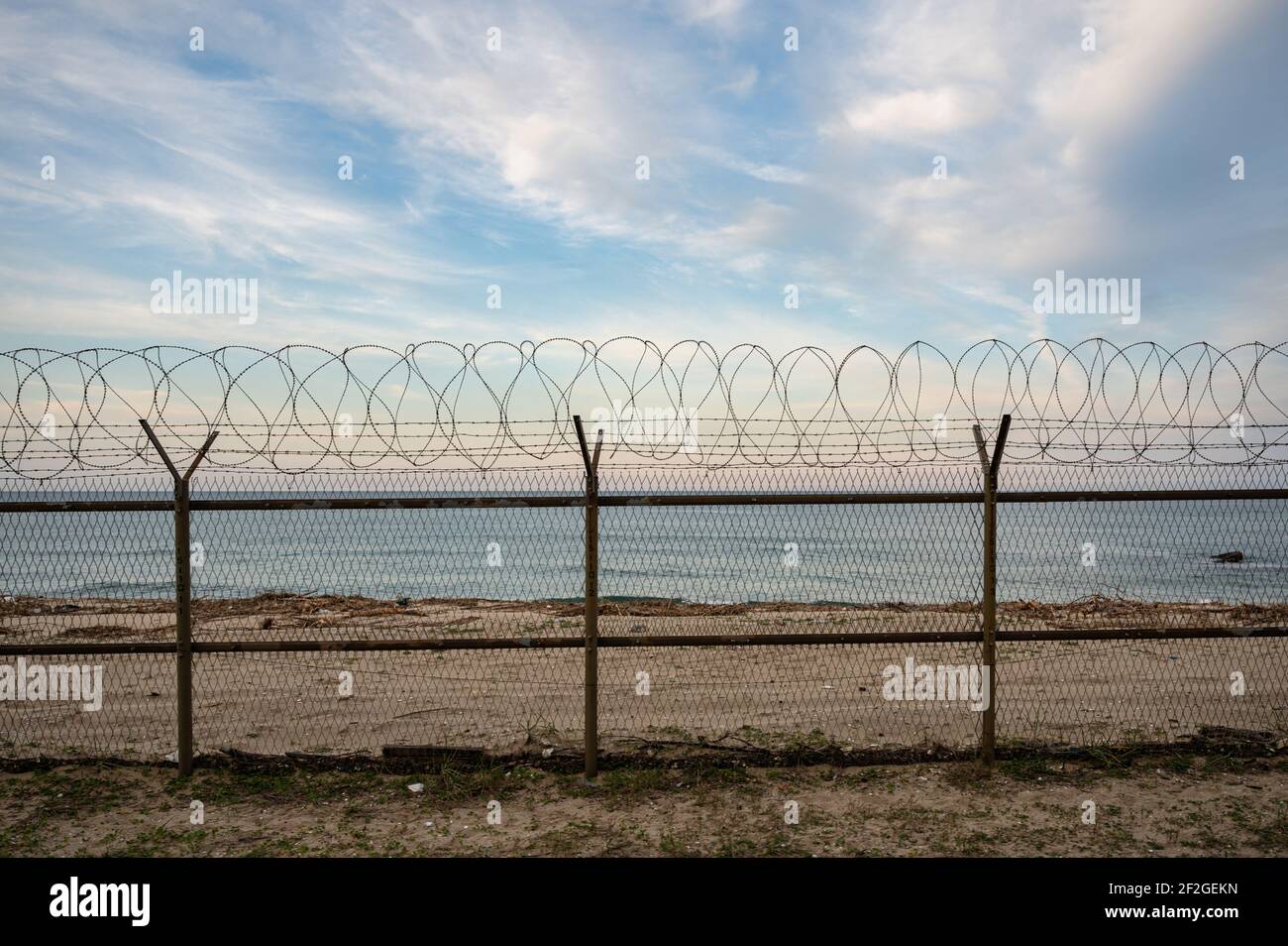 Barbed wire mesh fence on seashore at evening. Concept of freedom Stock ...