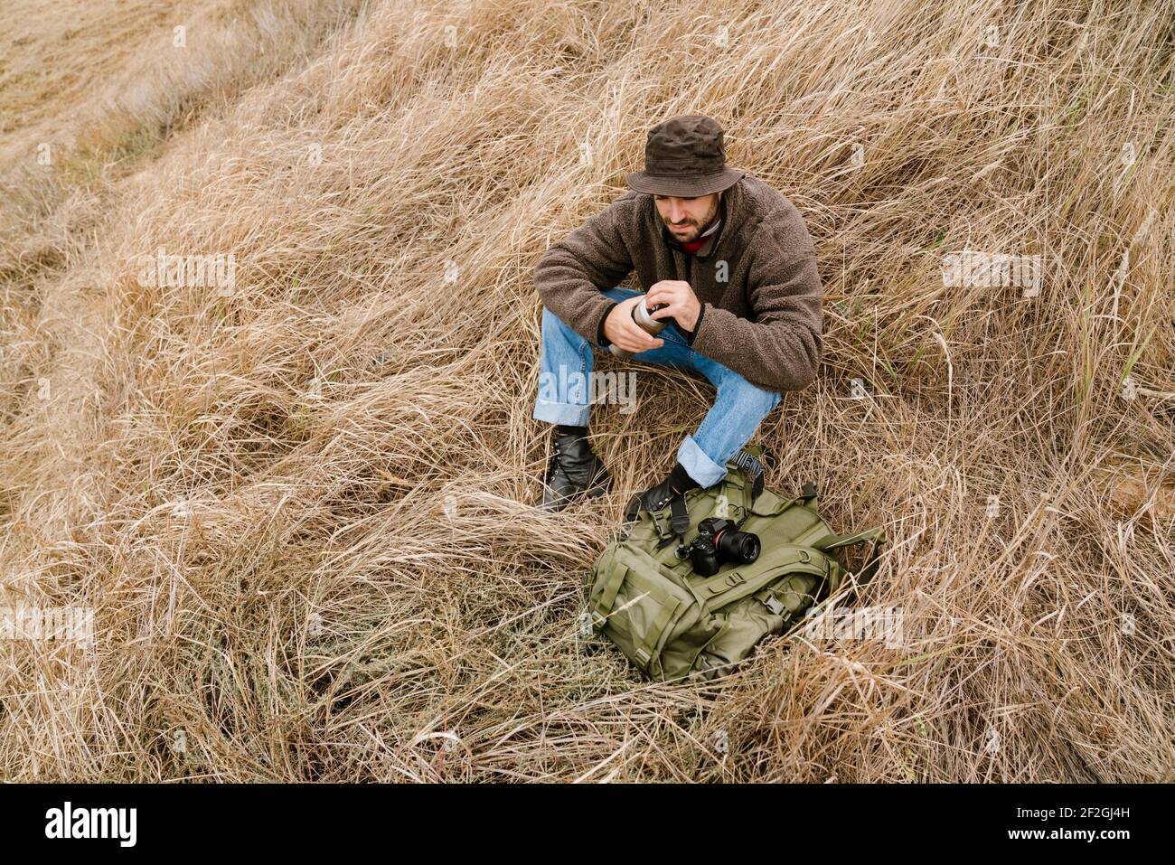 Serious handsome photographer drinking tea while resting outdoors Stock ...