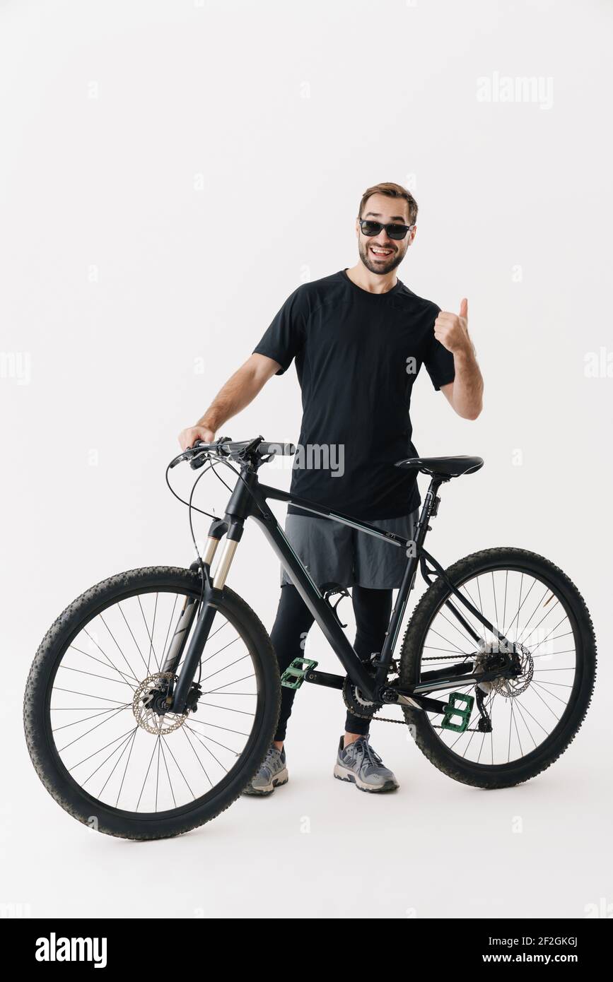 Happy rider man showing thumb up while posing with his bicycle isolated ...