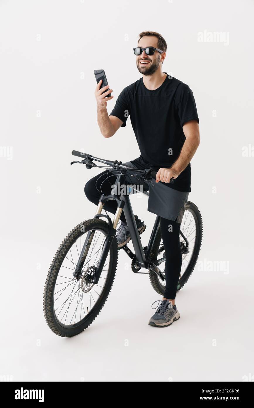 Happy rider man using cellphone while riding his bicycle isolated over ...