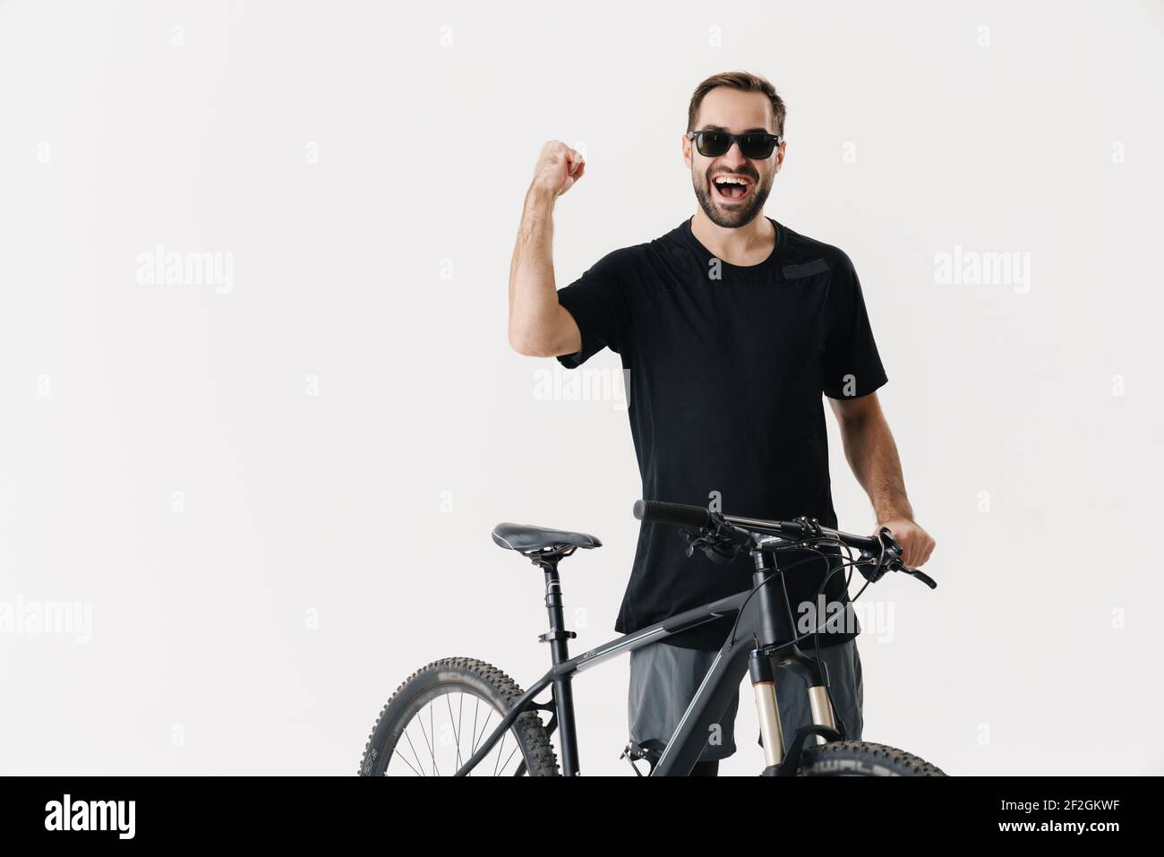 Happy cyclist sportman with a bicycle isolated over white background ...