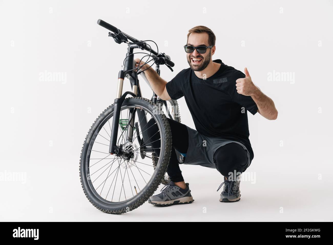 Happy rider man showing thumb up while posing with his bicycle isolated ...