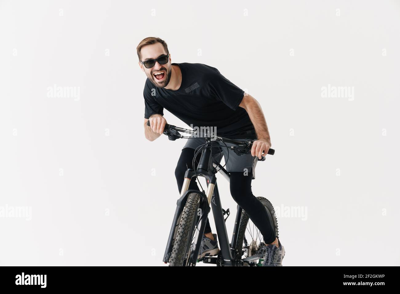 Happy excited cyclist sportman on a bicycle isolated over white ...