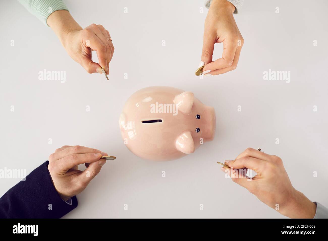Hand putting money into bank hi-res stock photography and images - Alamy