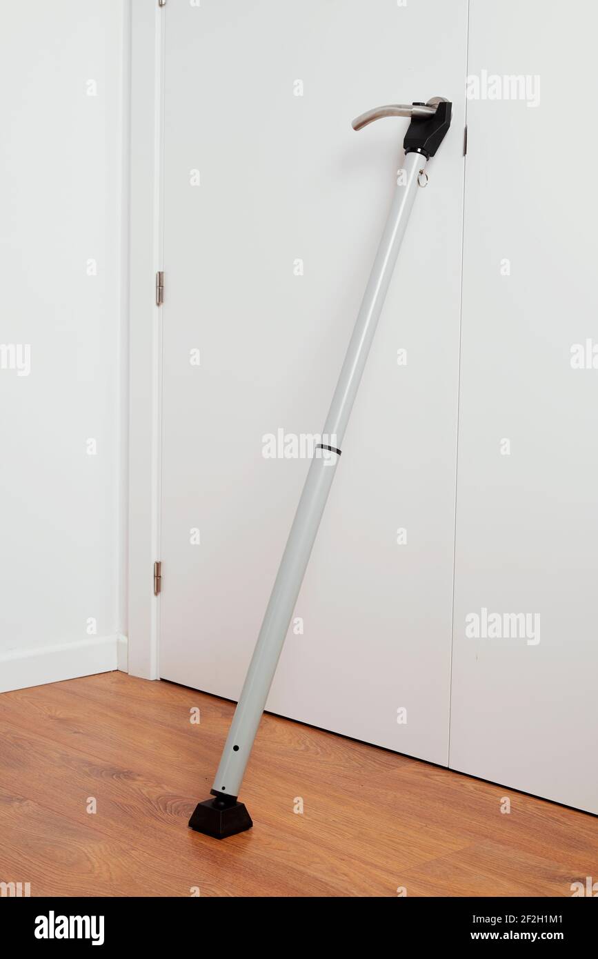 a door blocker security bar in use by reinforcing the white door of a ...