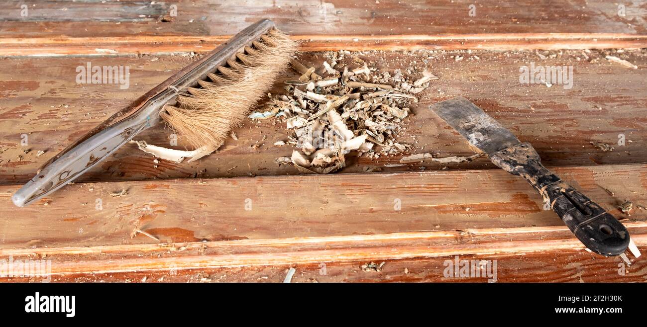 spatula and brush cleaning doors from old paint,restoration of wooden ...