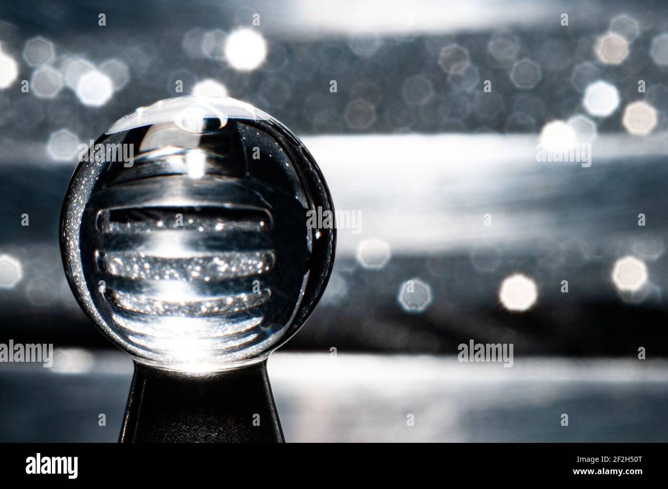 Crystal ball in gray glitter background with metal grid reflection ...