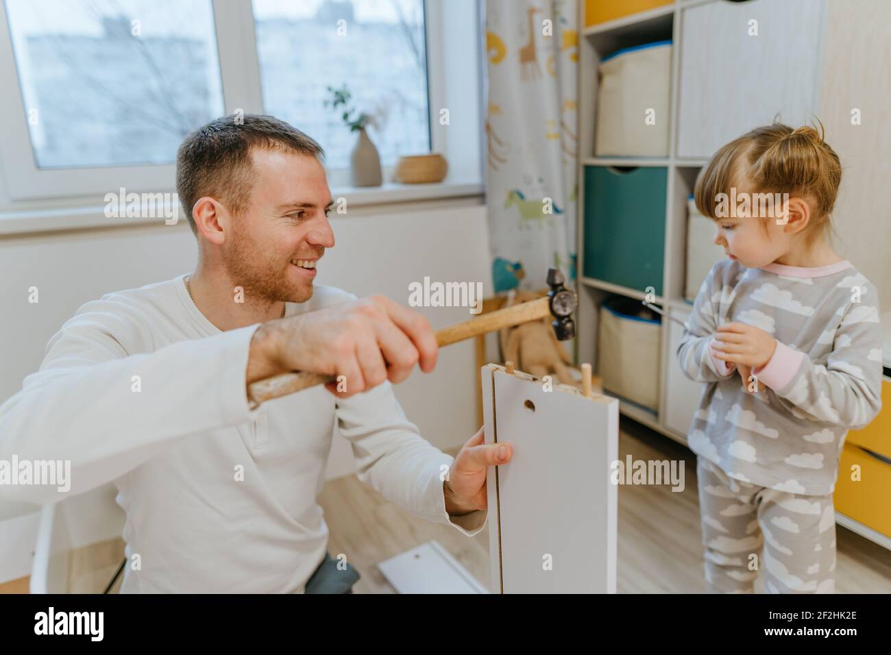 Little 4-years girl helps her father assemble or fixing the drawer of ...