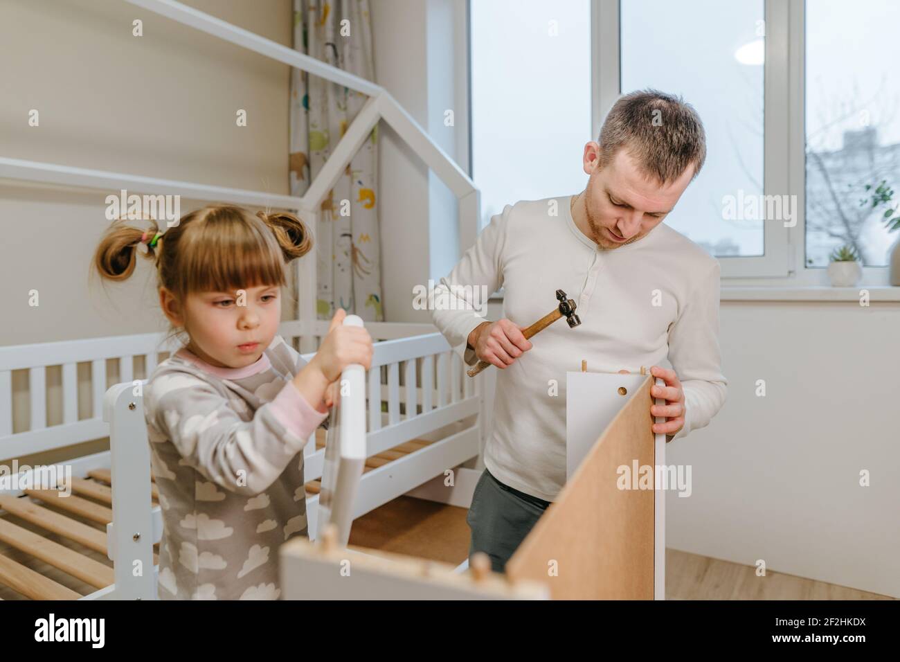 Little 4-years girl helps her father assemble or fixing the drawer of ...