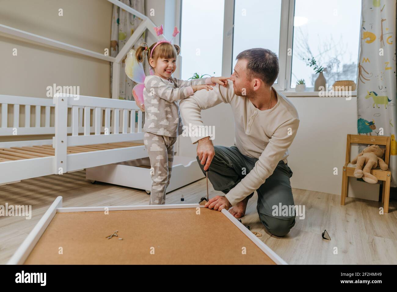 Little 4-years girl helps her father assemble or fixing the drawer of ...