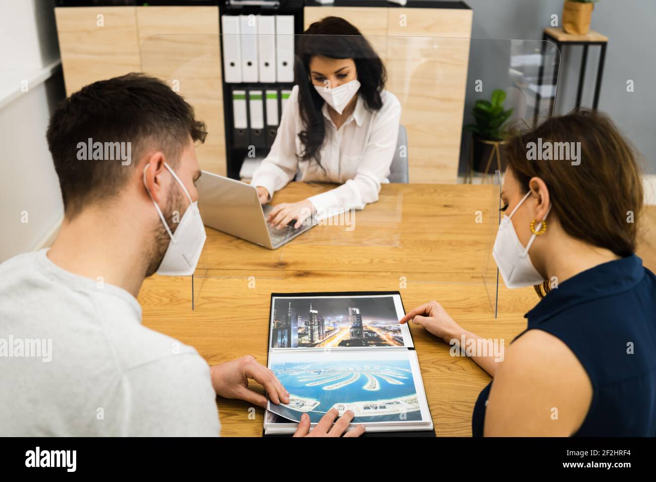 Young Couple With Travel Agent Wearing Face Mask Stock Photo - Alamy