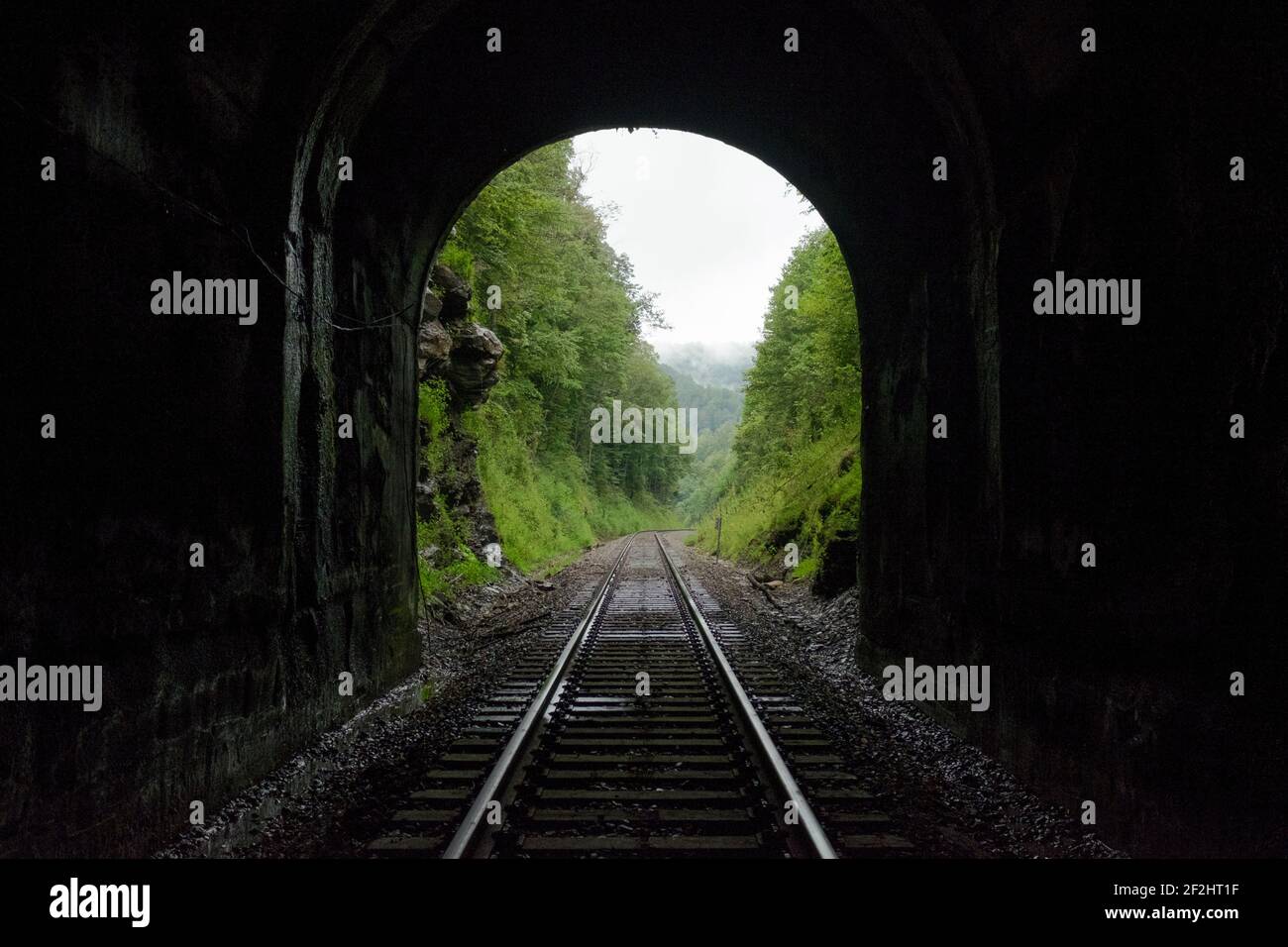 A rail, train line comes out of a stone tunnel in the Appalachian ...