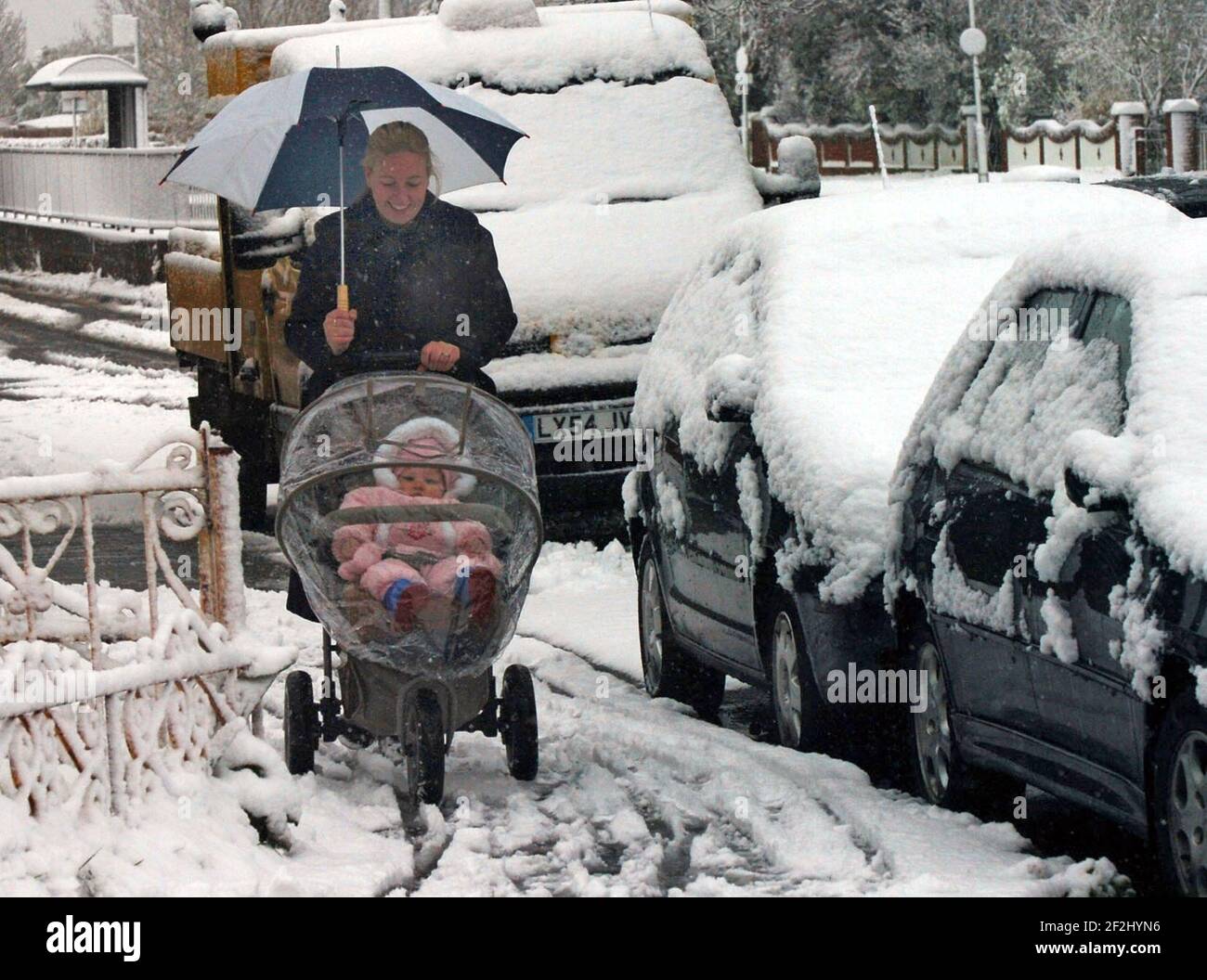 A YOUNG MUM STRUGGLES THROUGH THE SNOW WITH HER PUSHCHAIR AT ...