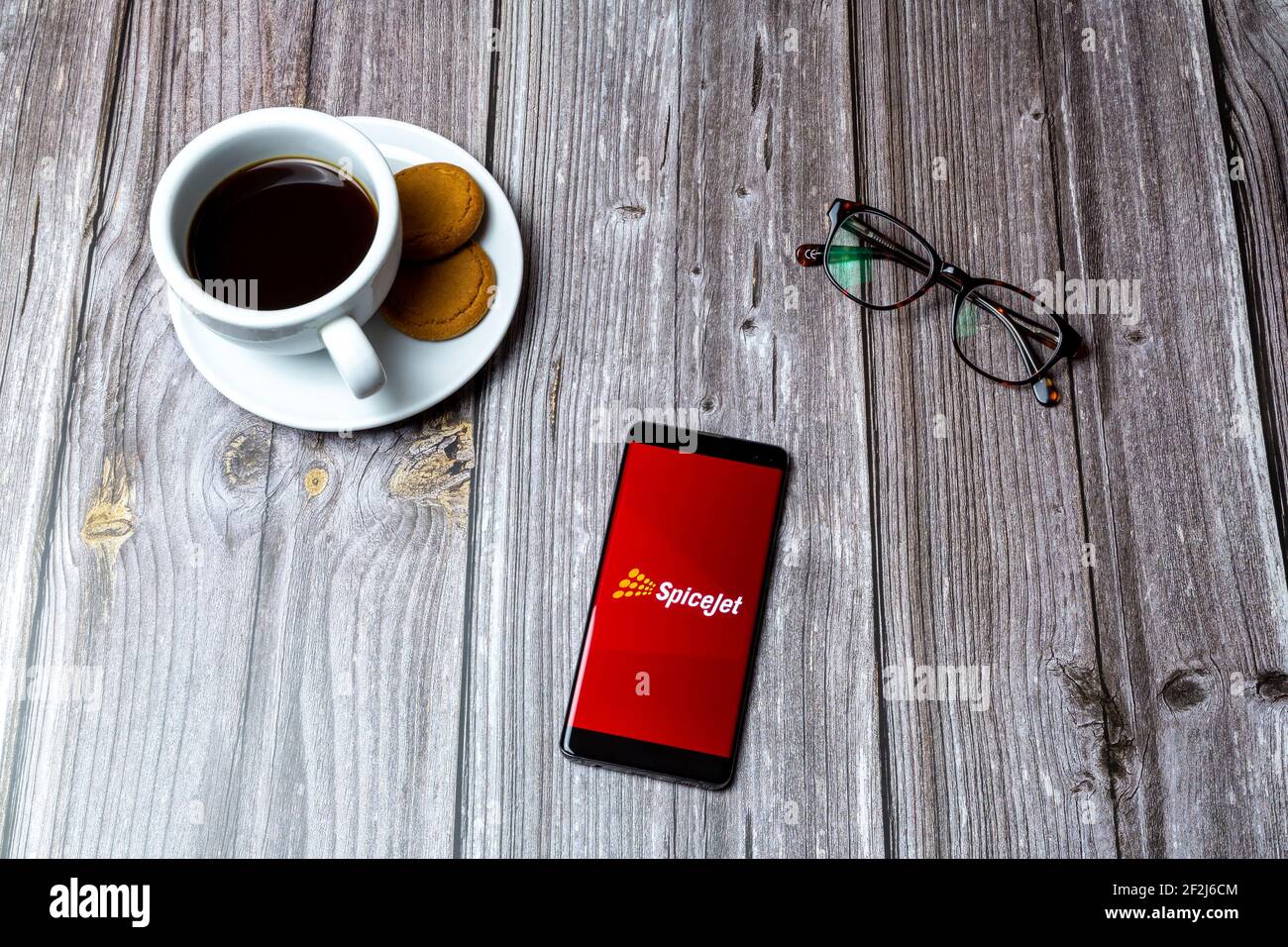 A Mobile phone or cell phone laid on a wooden table with the Spicejet ...