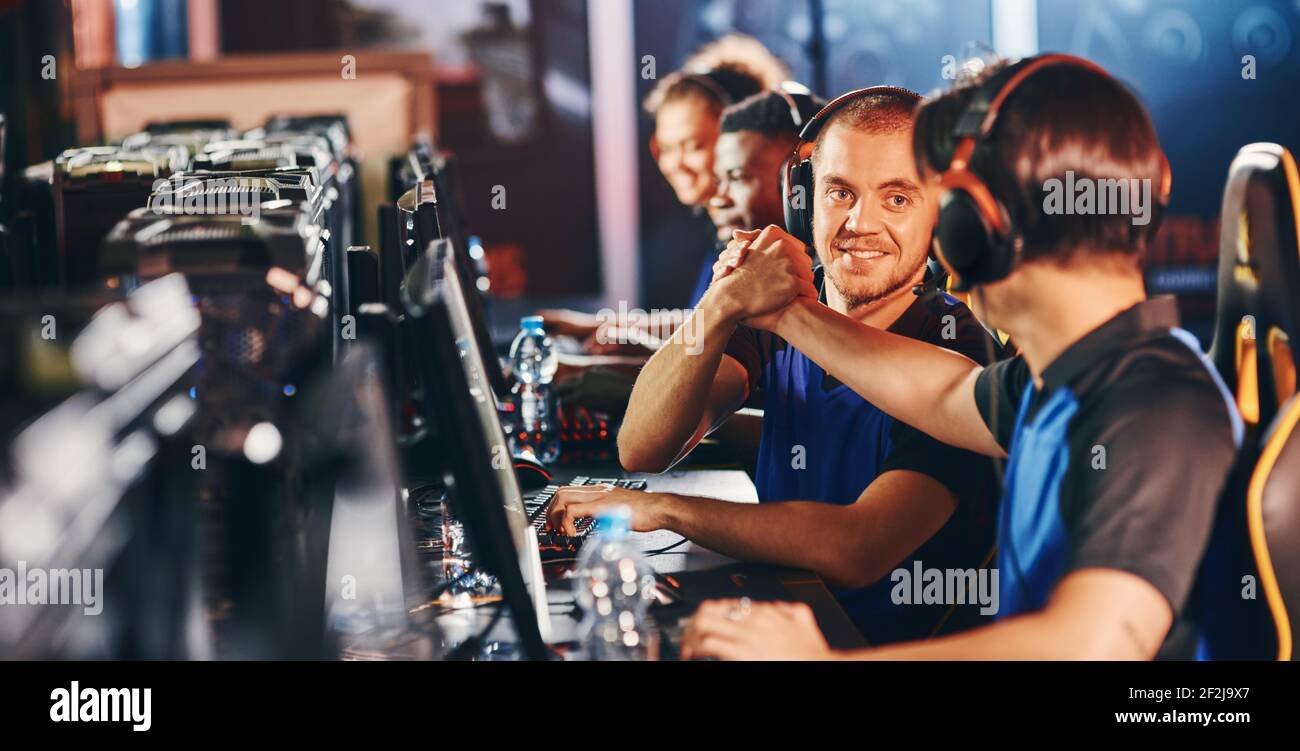 Professional cybersport team. Two happy male gamers shaking hands ...