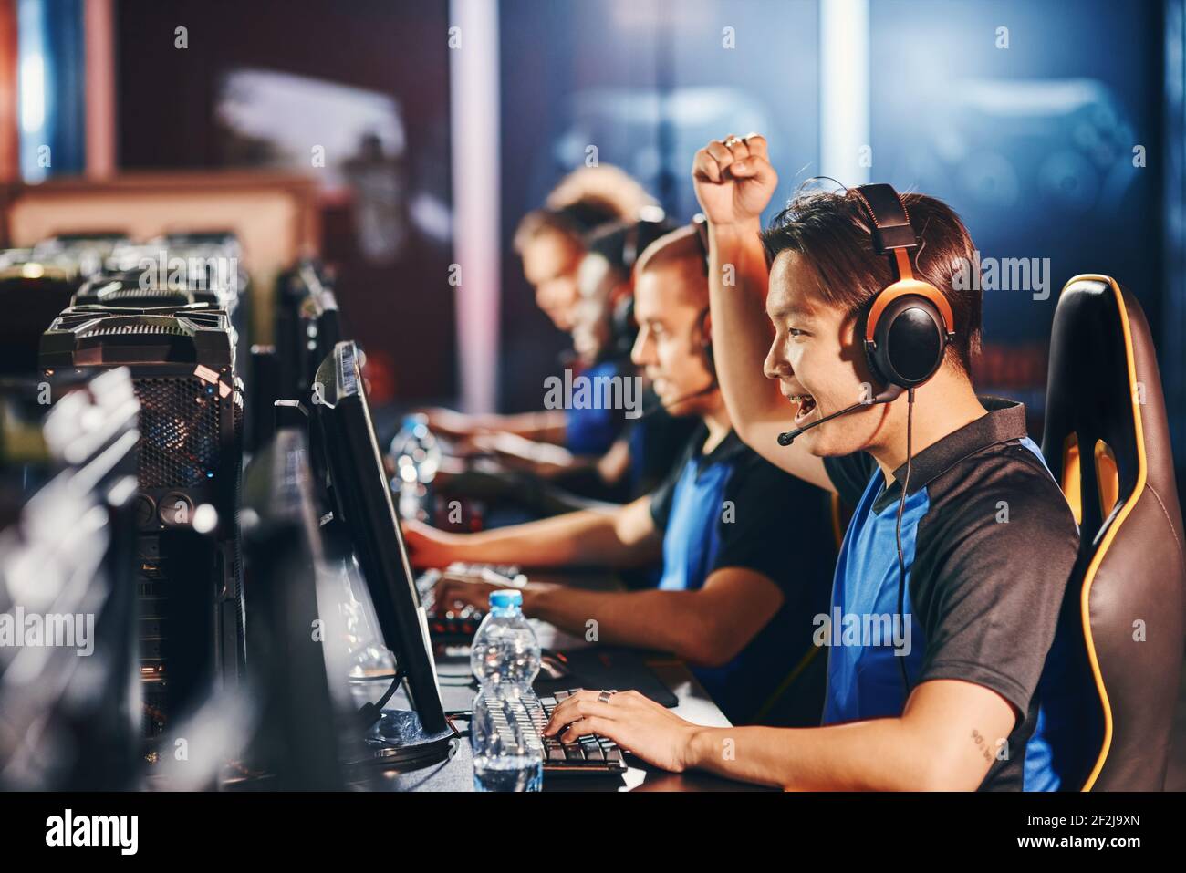 Side view of excited young asian guy, male cyber sport gamer looking at ...