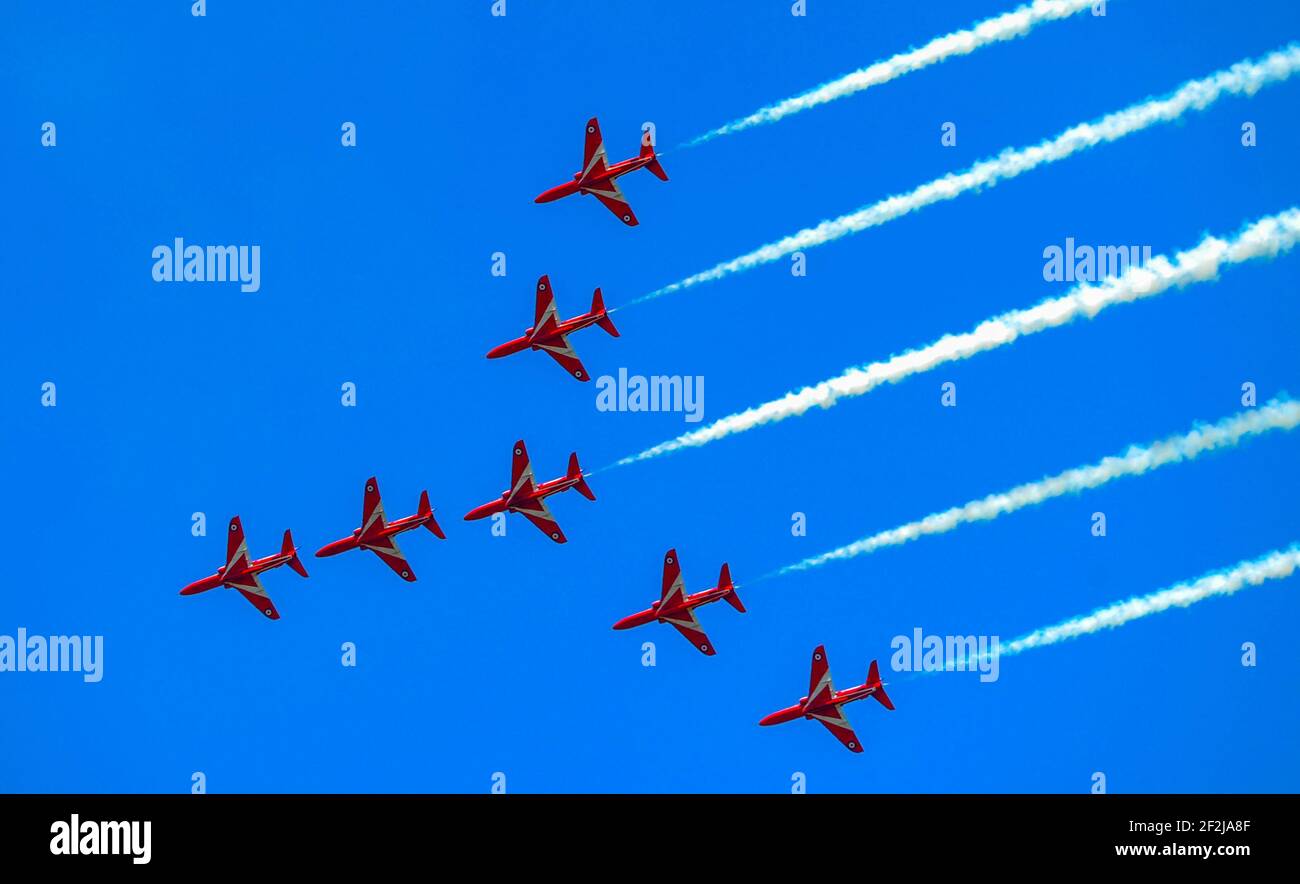 The British RAF Red Arrows in formation against a blue sky with ...