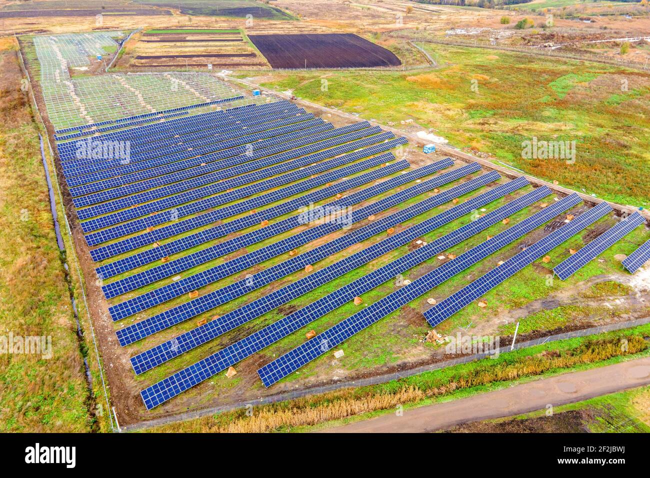 Aerial view of solar power plant under construction on green field ...