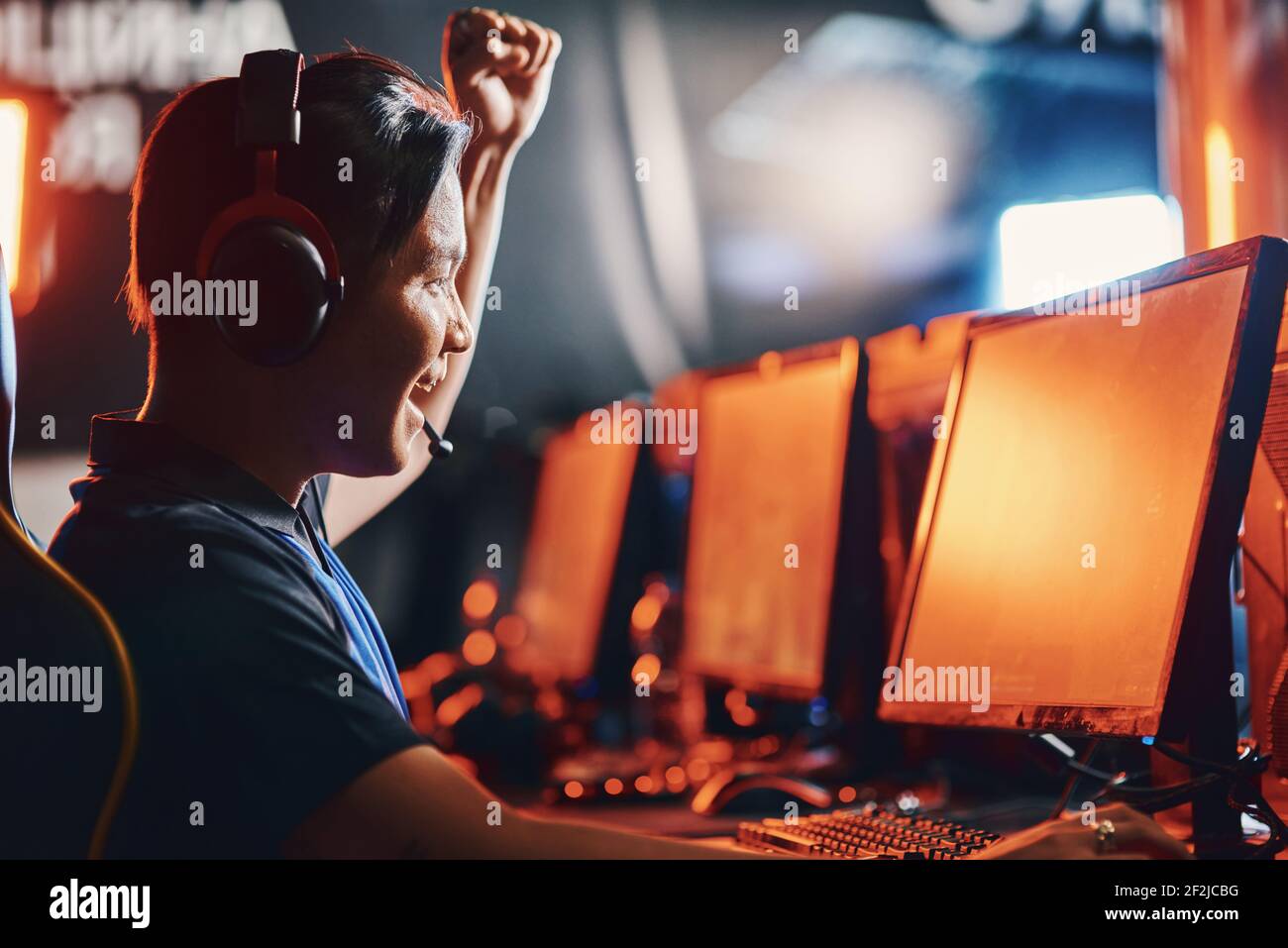 Side view of young excited asian guy, male professional cybersport ...