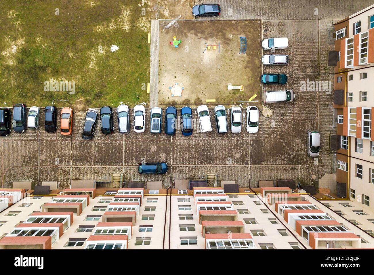 Aerial view of parked cars on parking lot between high apartment ...