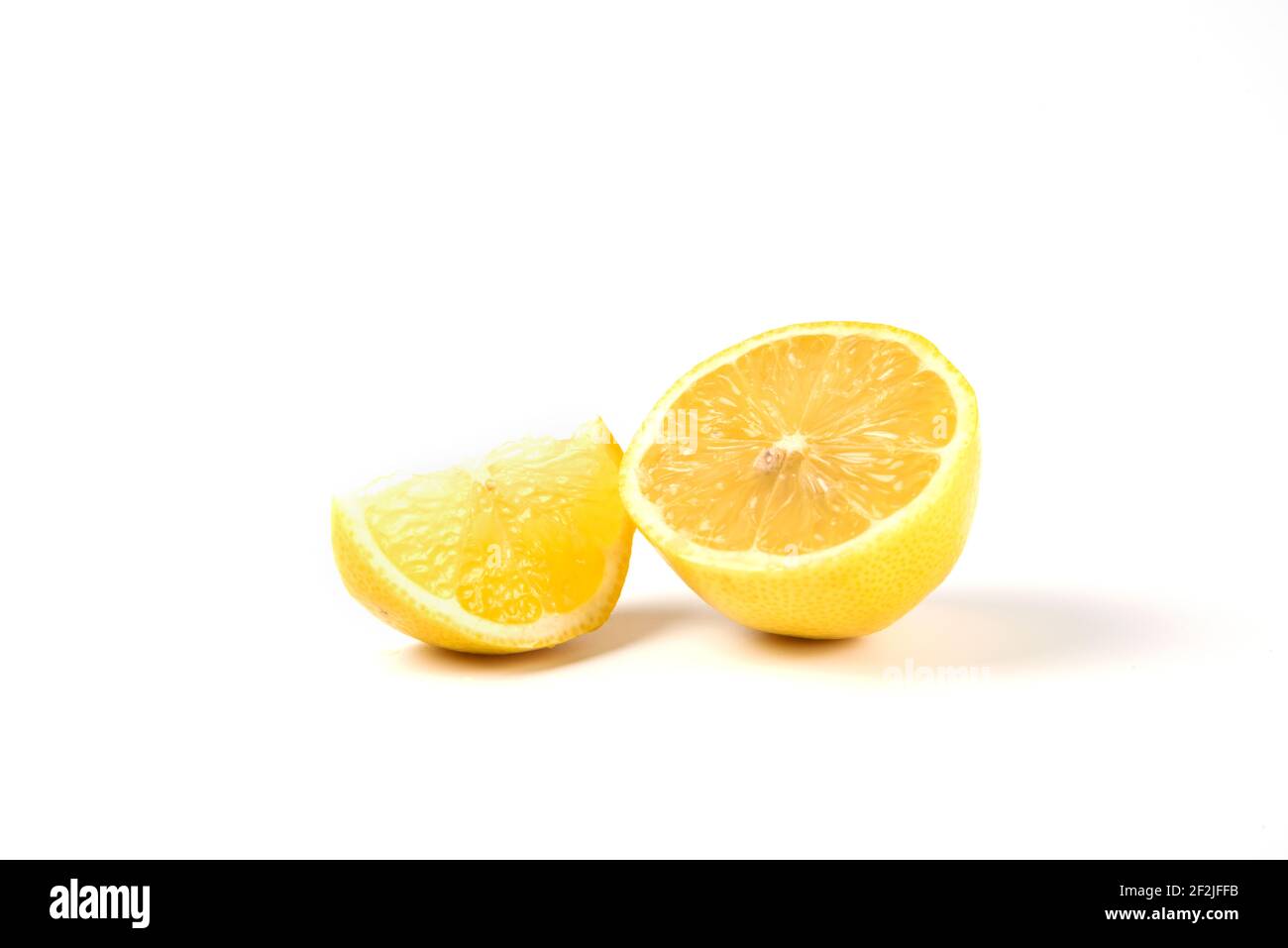 A slice and half lemons isolated on white background Stock Photo - Alamy