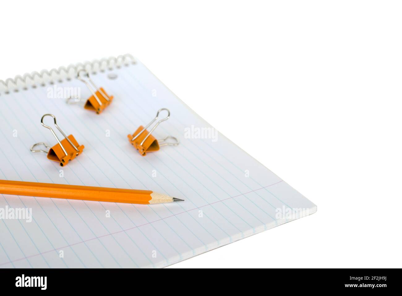Notebook, pencil and binder clips on white background. Blank spiral ...