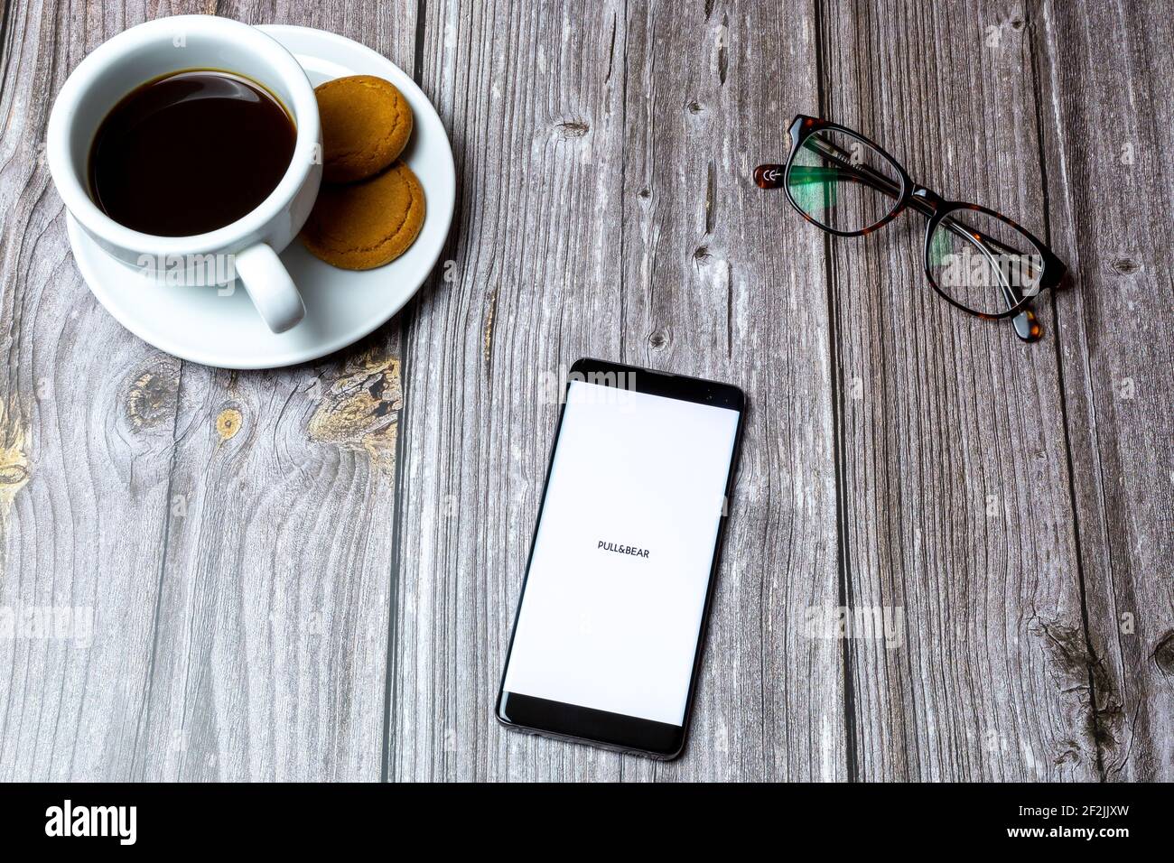 A Mobile phone or cell phone laid on a wooden table with the Pull ...