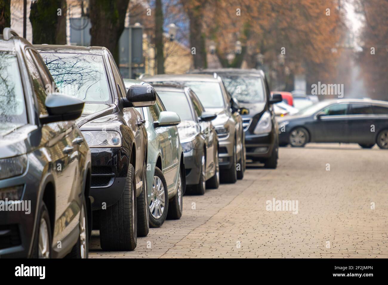 Cars parked in a row on a city street side Stock Photo - Alamy