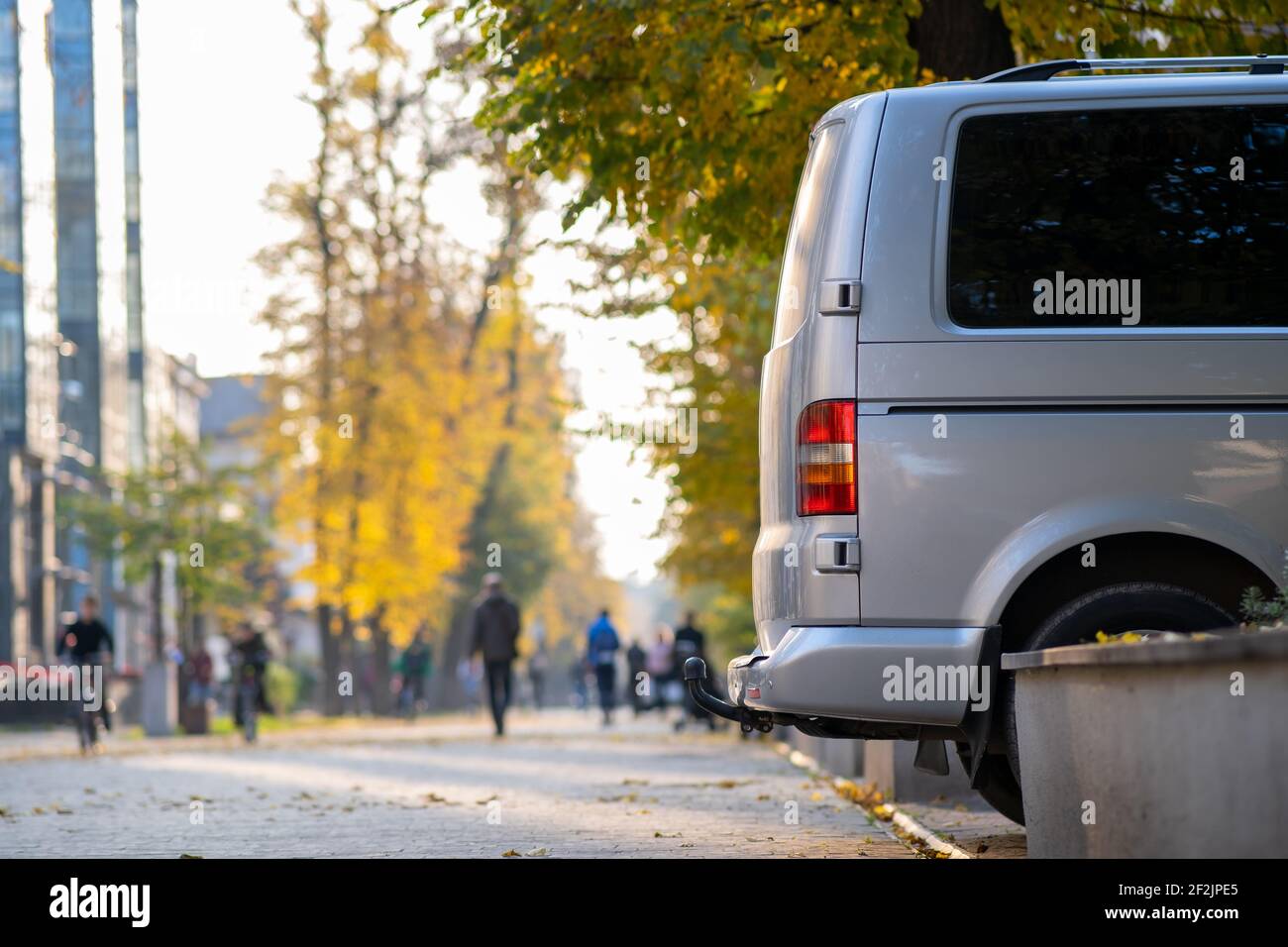 Passenger van car parked on a city alley street side with blurred ...