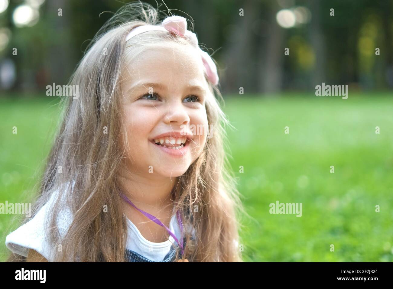 Portrait of pretty child girl in summer park smiling happily Stock ...
