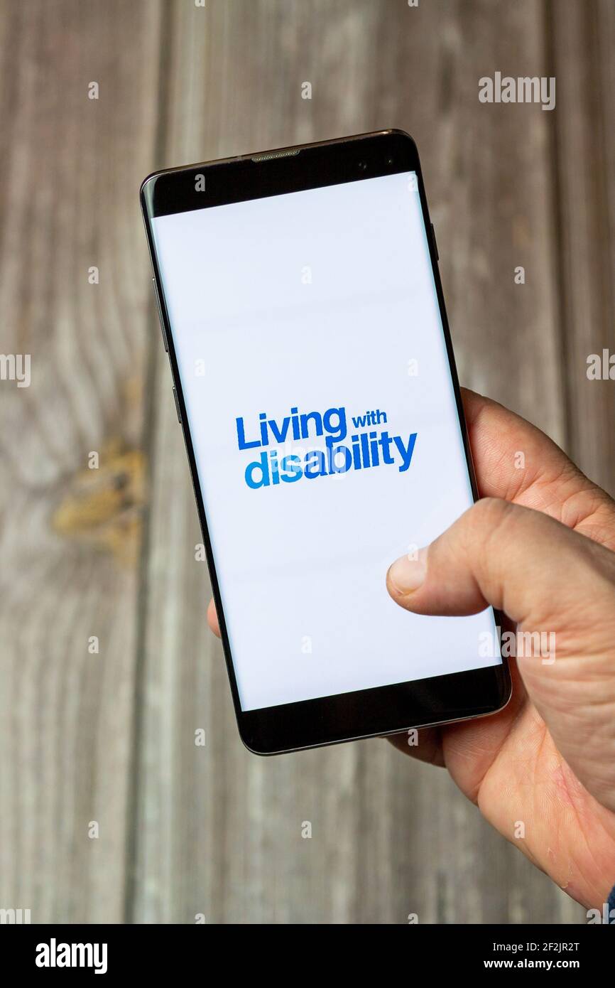 A Mobile phone or cell phone being held in a hand with the Living with ...