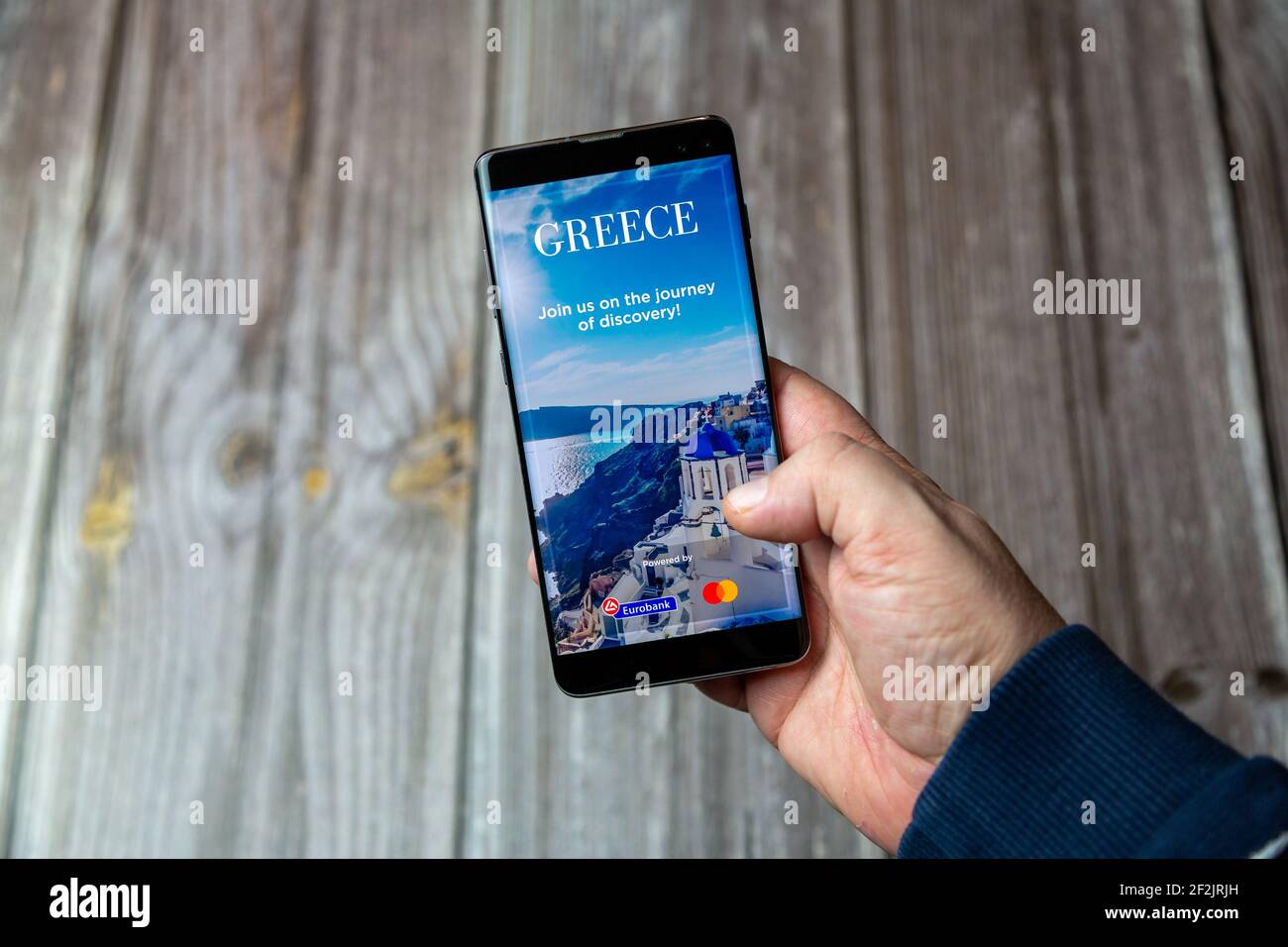 A Mobile phone or cell phone being held in a hand with the Visit Greece ...