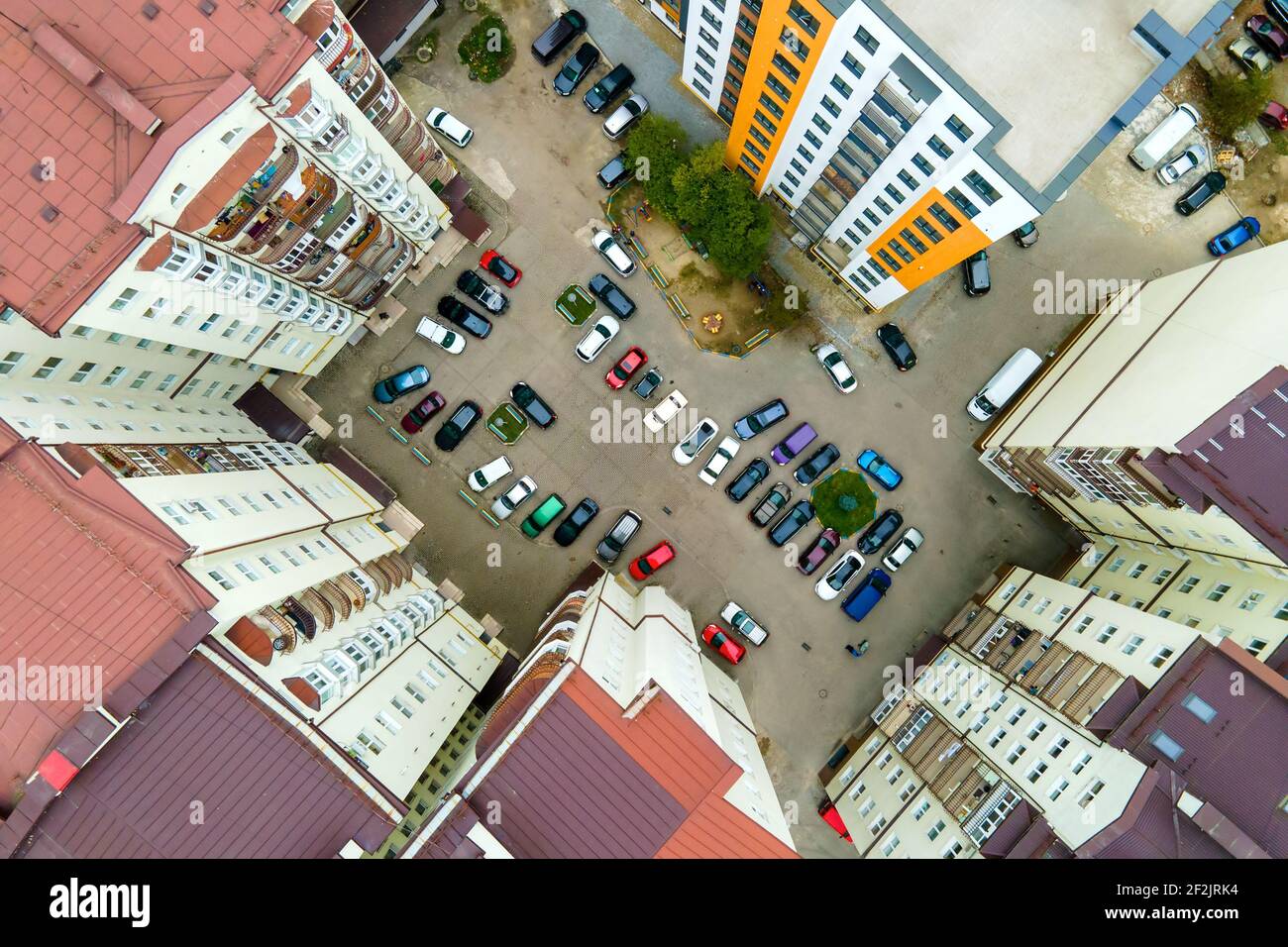 Aerial view of parked cars on parking lot between high apartment ...