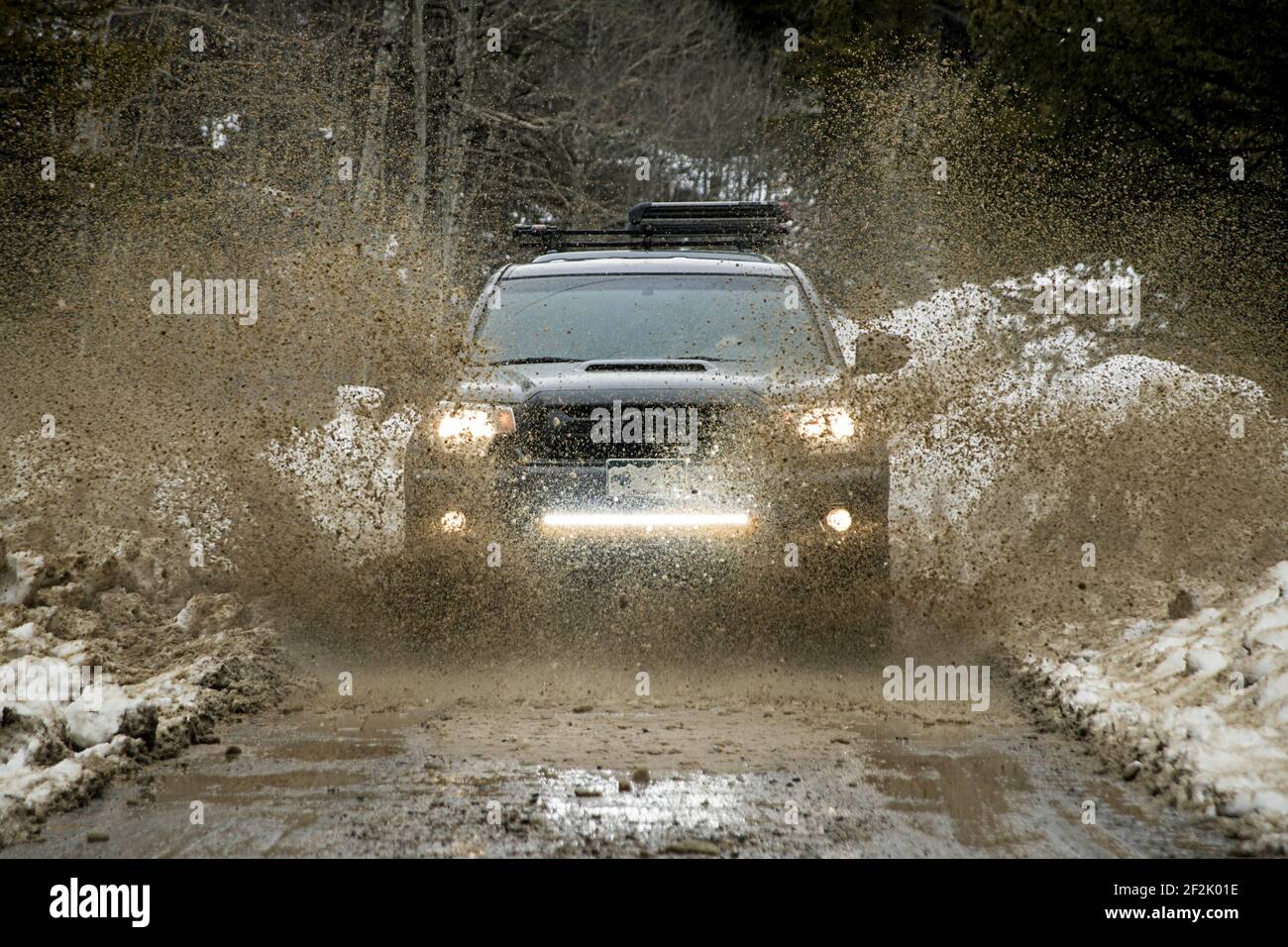 Truck driving through mud in spring Stock Photo - Alamy