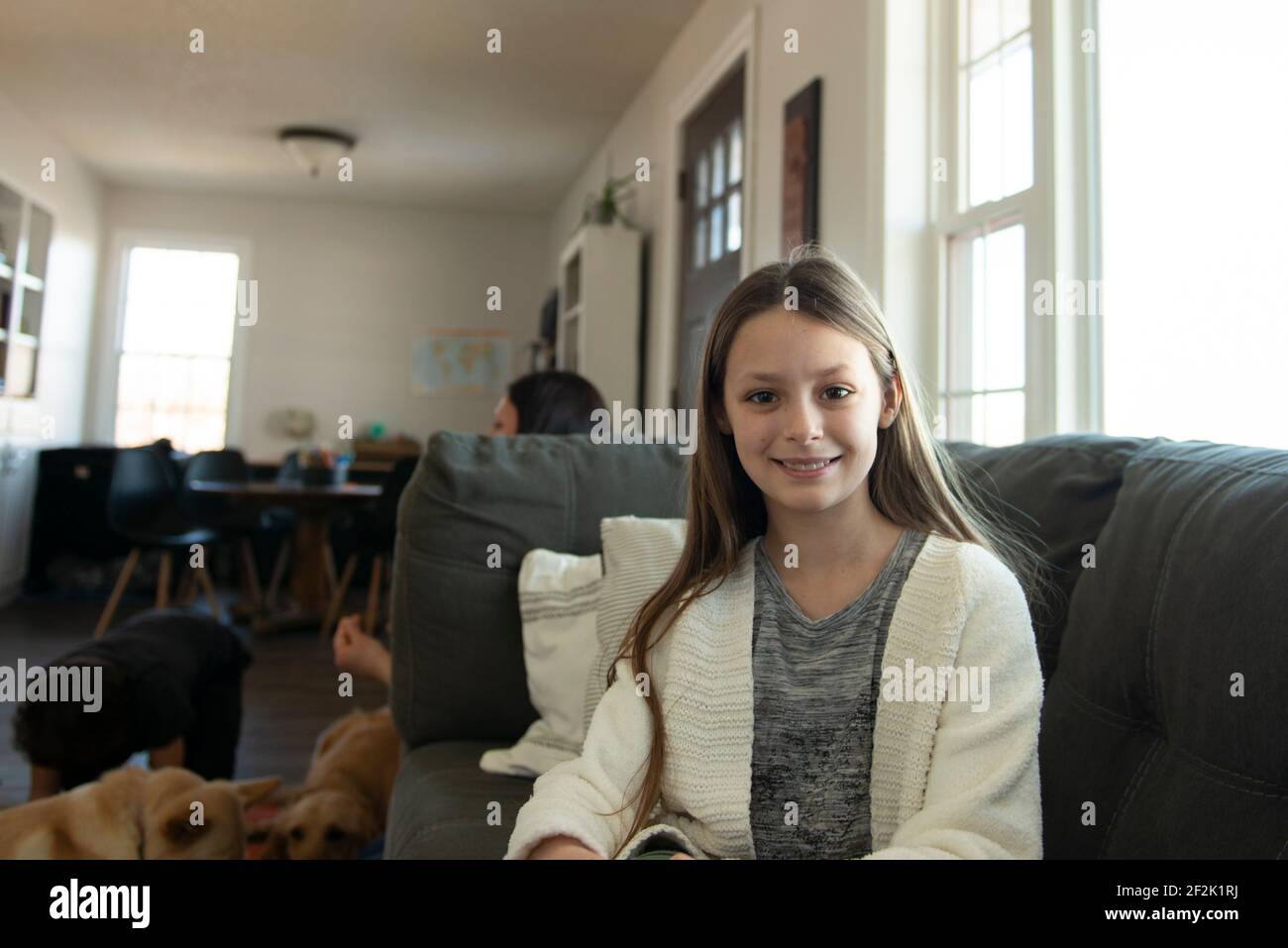 Beautiful tween girl sitting on the couch by window Stock Photo - Alamy