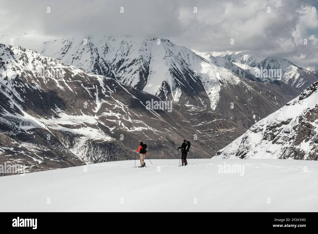 Male friends with splitboards on snowfield against mountain range ...