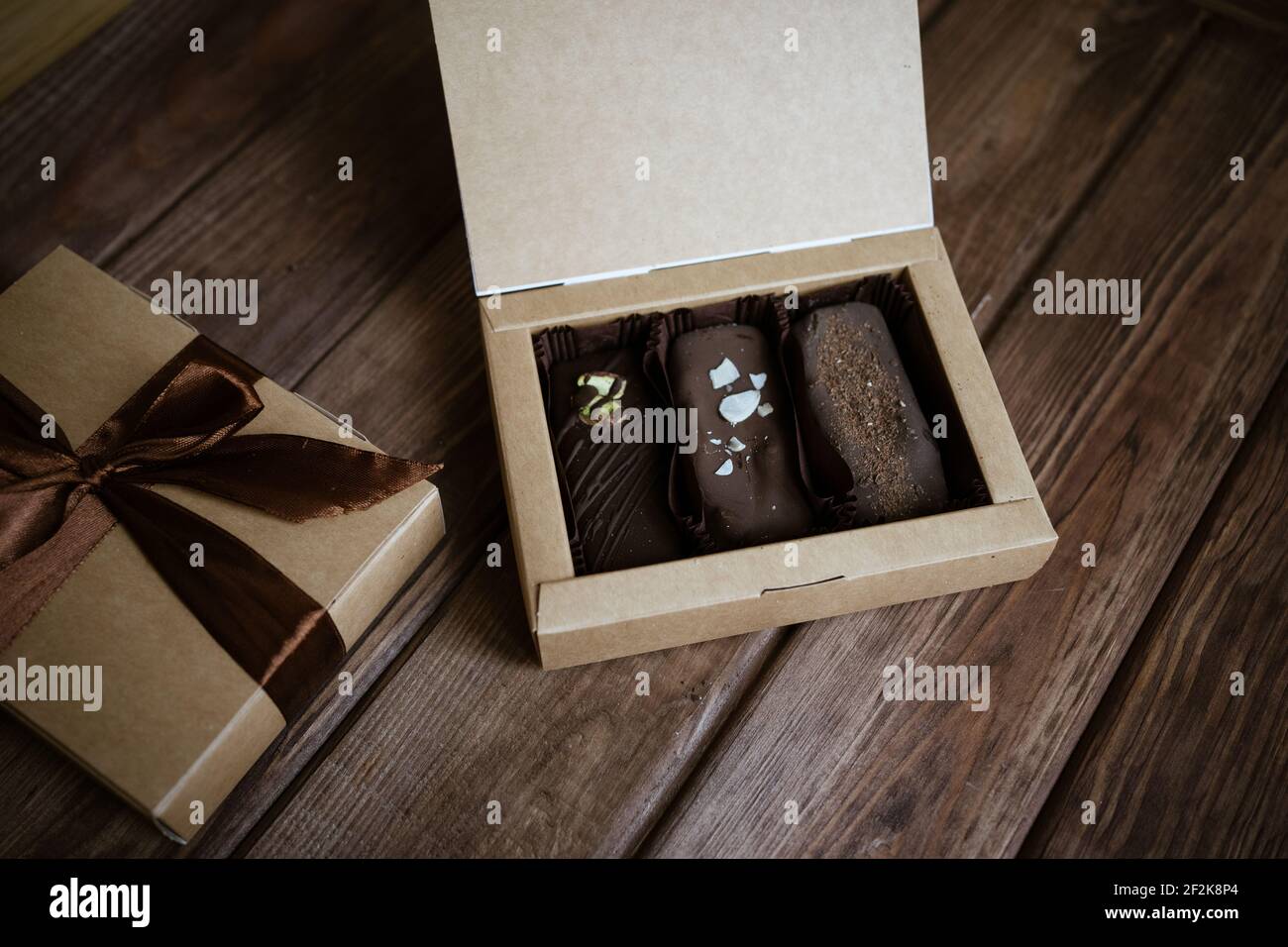 three chocolate bars on a wooden background Stock Photo - Alamy