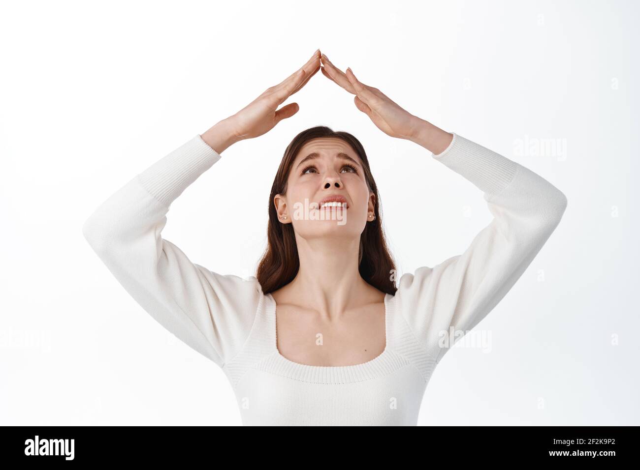 Image of young woman struggling make roof with hands above head ...