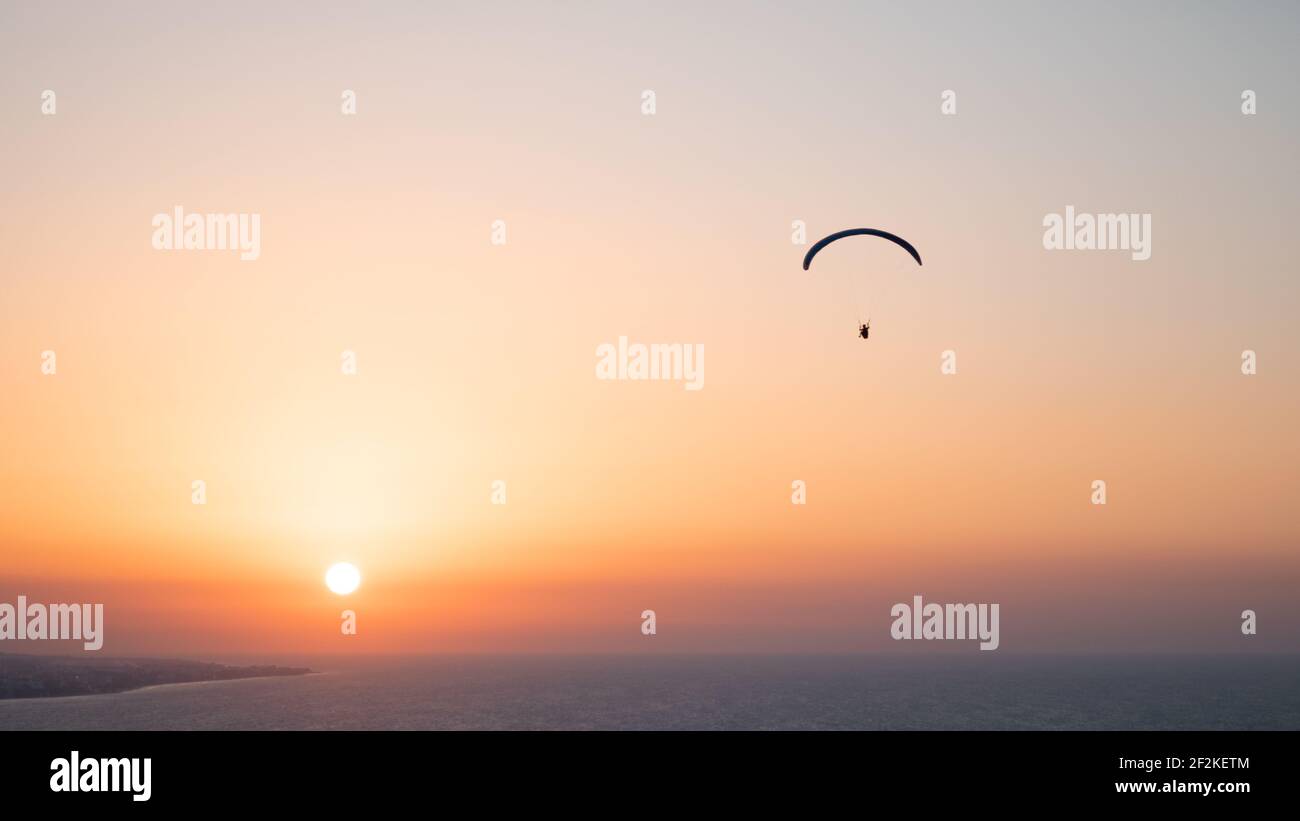 Amazing paragliding in sunset Stock Photo - Alamy