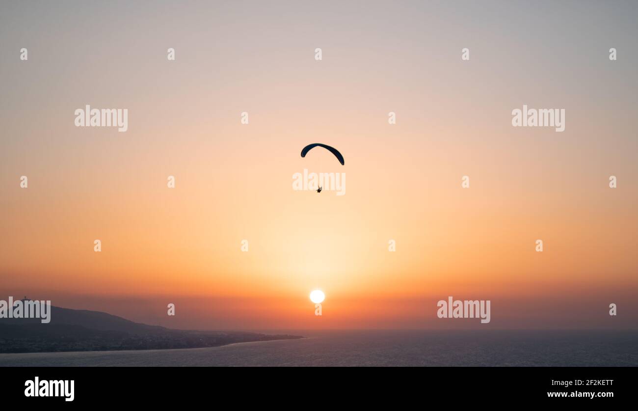 Amazing paragliding in sunset Stock Photo - Alamy