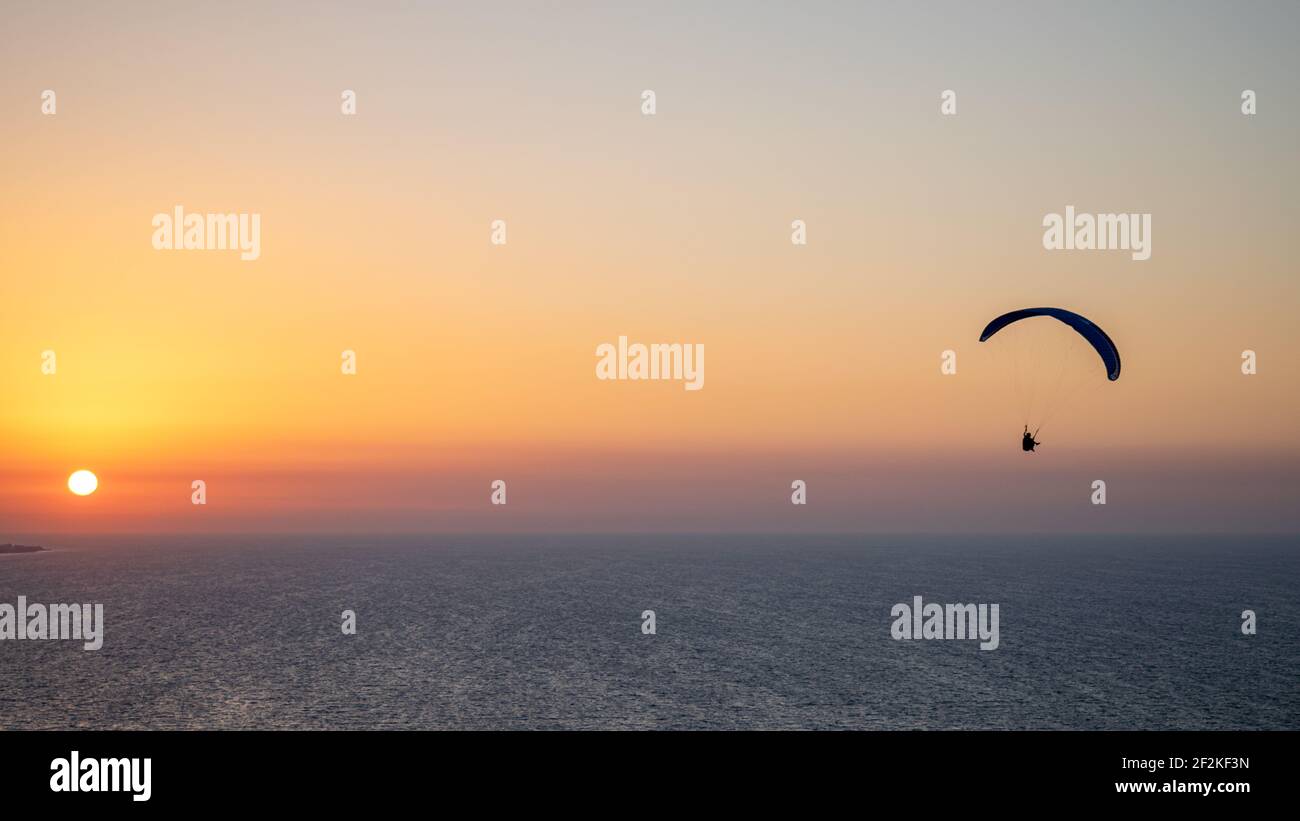 Amazing paragliding in sunset Stock Photo - Alamy