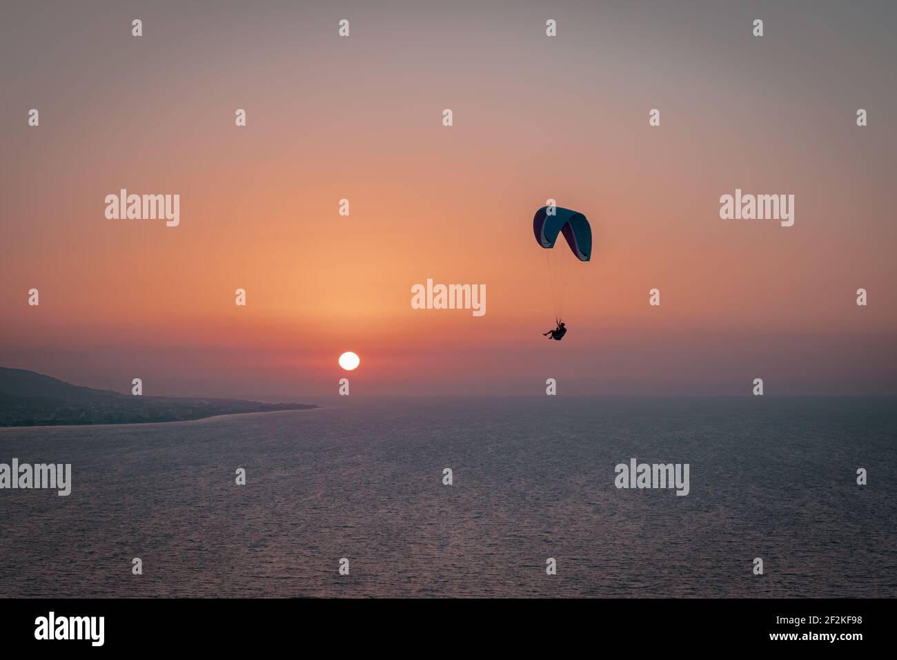 Amazing paragliding in sunset Stock Photo - Alamy