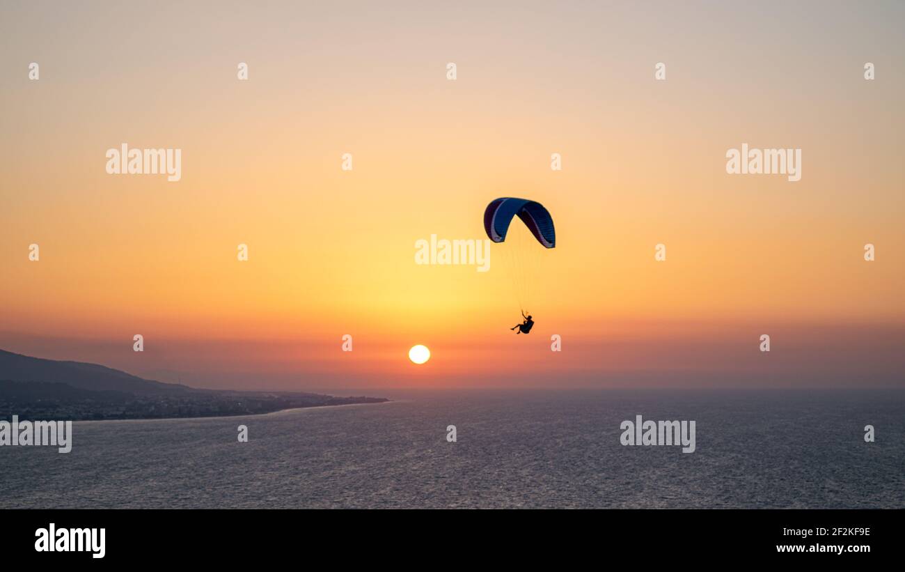 Amazing paragliding in sunset Stock Photo - Alamy