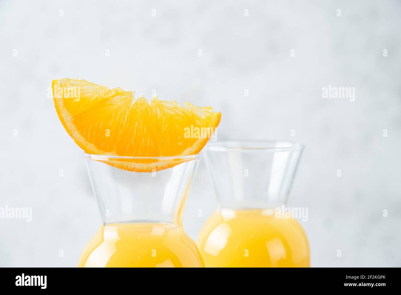 Glass pitchers of juice with slice of orange fruit Stock Photo - Alamy