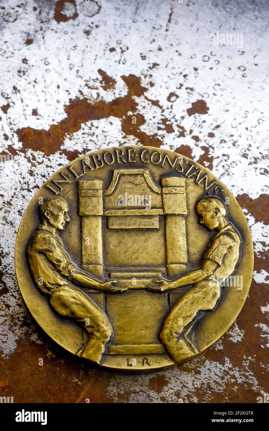 Bronze medal, with two workers and the words "Hard workers ...