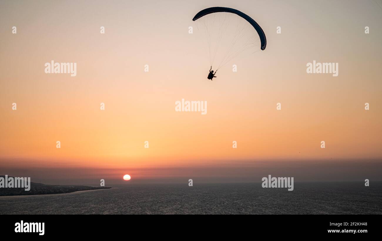 Amazing paragliding in sunset Stock Photo - Alamy