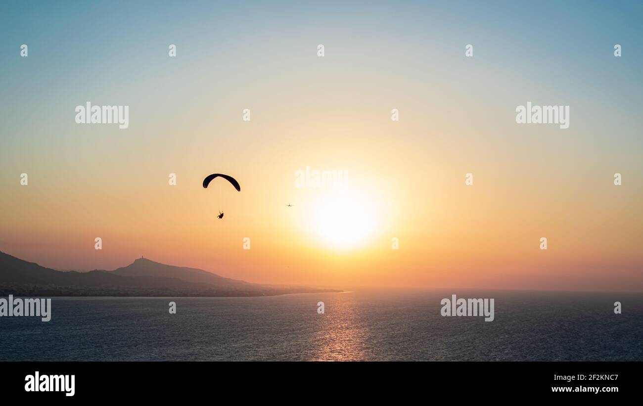 Amazing paragliding in sunset Stock Photo - Alamy