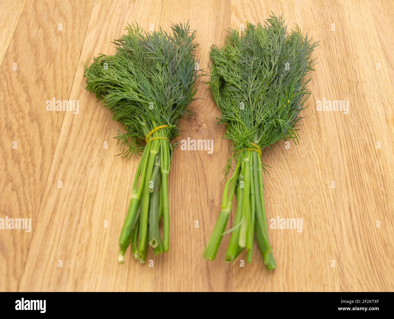 Dill on a wooden background. the benefits of dill Stock Photo - Alamy